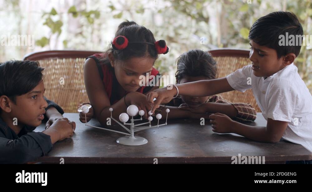 Group of Indian kids learning from practical experiments from teacher ...