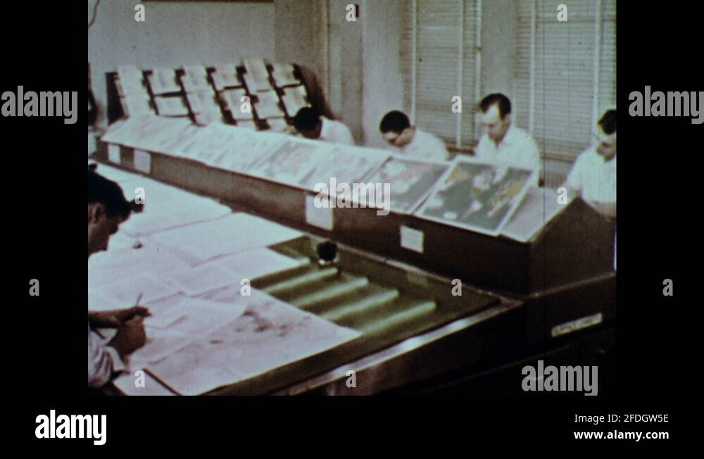 1960s: Men sit in rows at drafting tables drawing on weather maps. Man ...