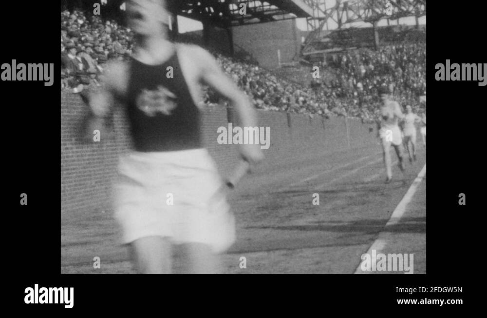 1920s: Full stadium, crowd, track and field competition, men run relay ...