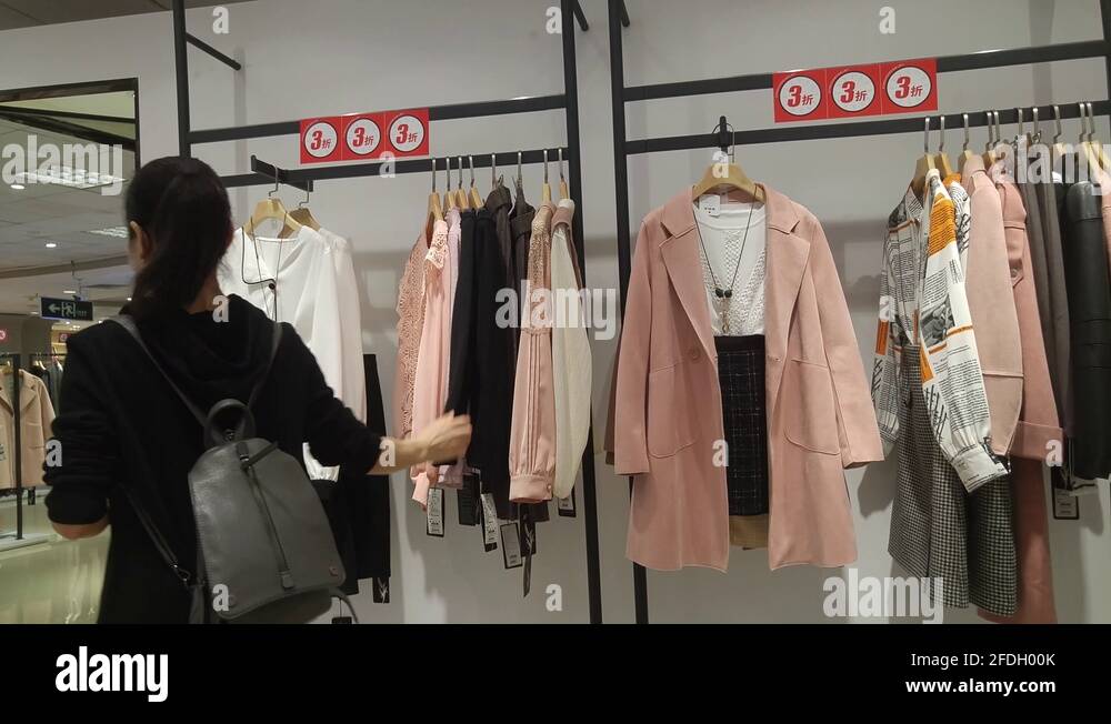 The young woman was shopping for clothes in the clothing store Stock ...