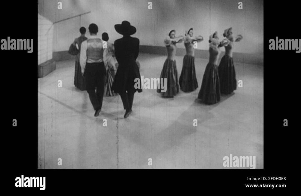 1950s: Men and women ballet performers circle and march around on stage ...