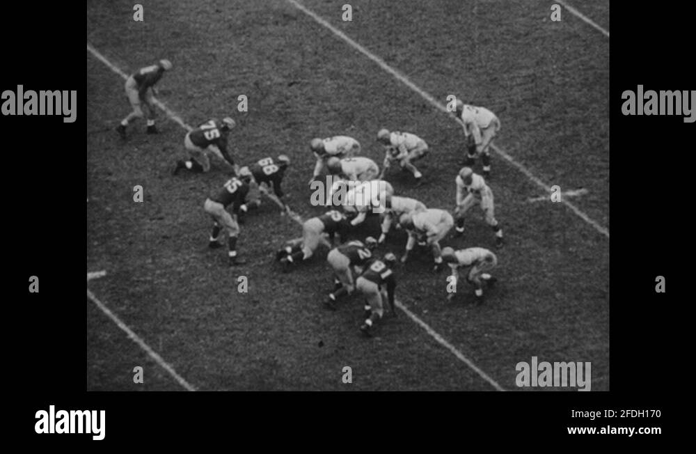 1940s: crowds of fans in stadium cheering, one team punts ball that ...