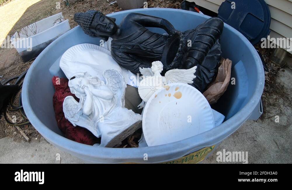 Religious statues in garbage can with trash being tossed on top 4k slow ...