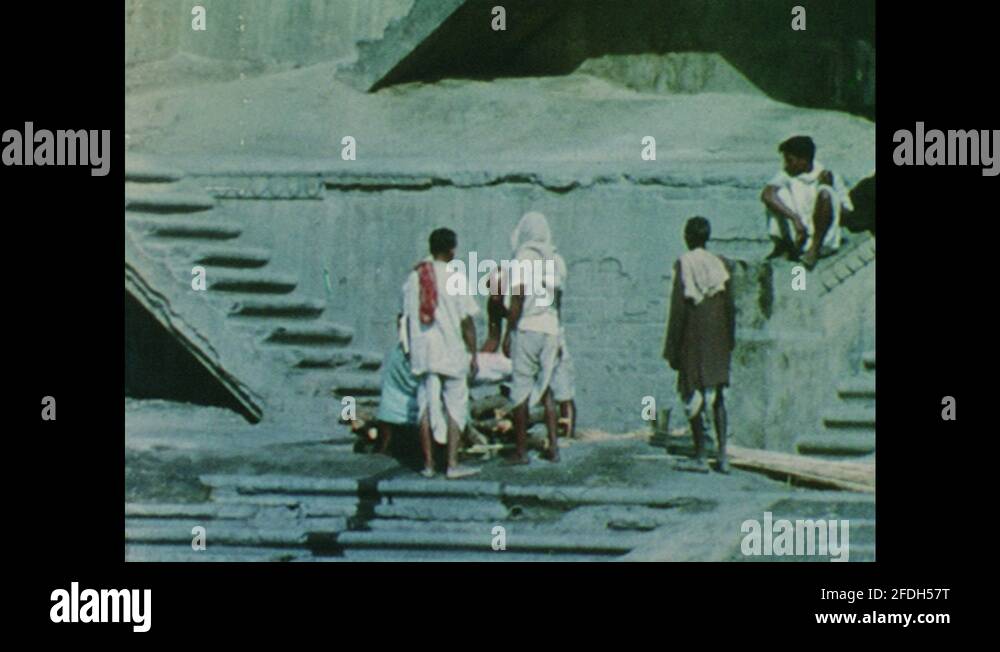 1960s: Men lay corpse on top of pyre. Man burns plant and walks around ...