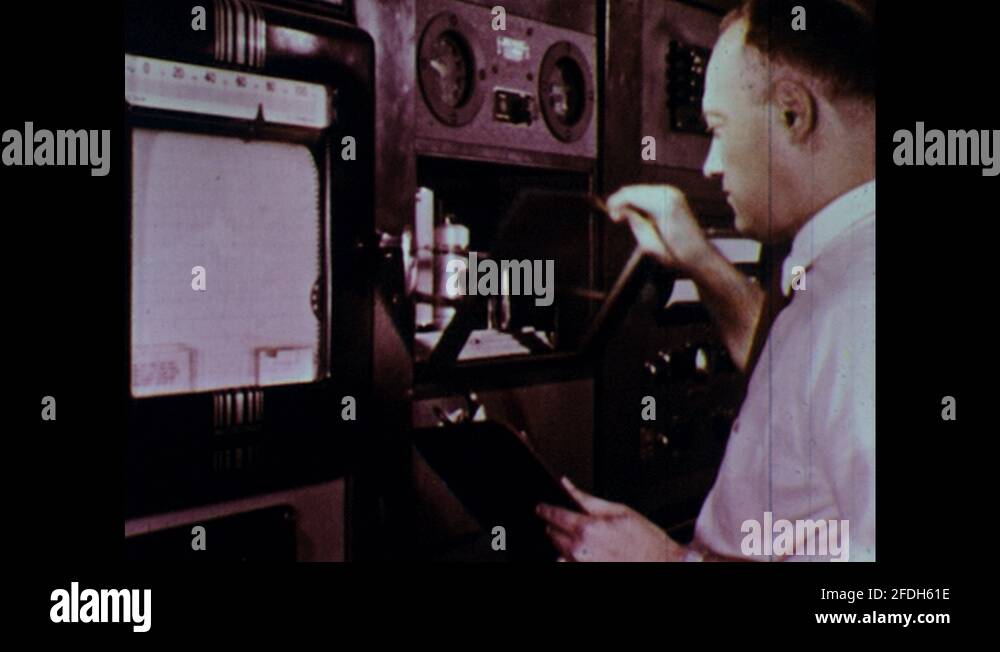 1960s: Man opens science machine and looks inside. Man polishes bulb on ...