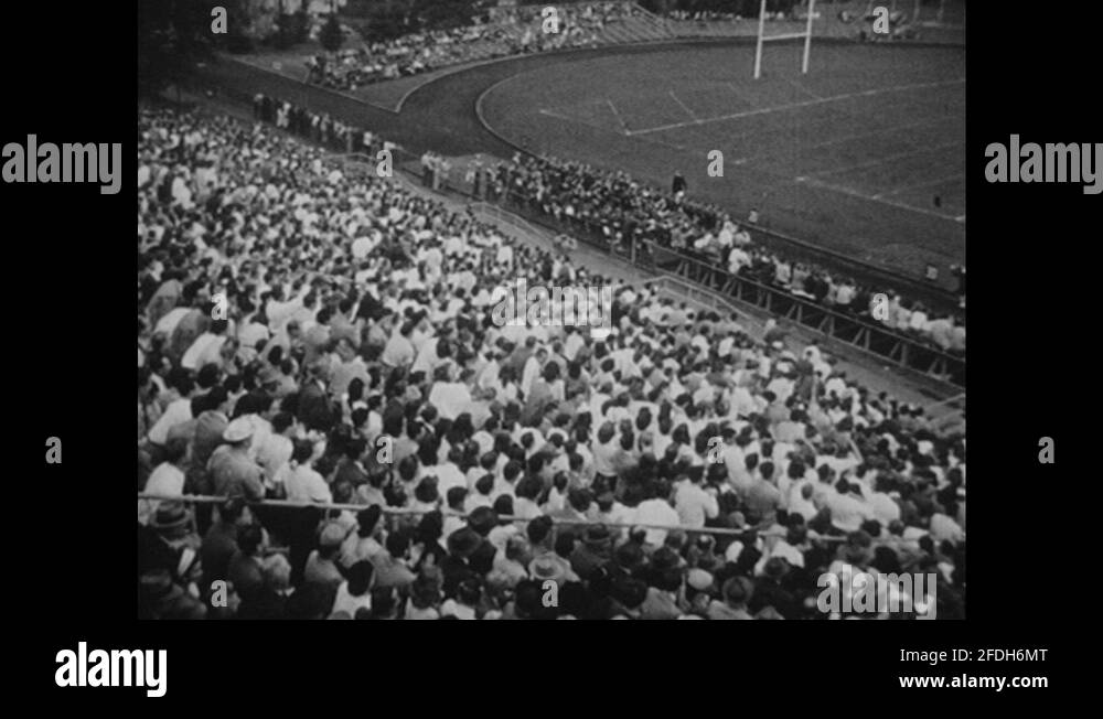 1940s: crowds of fans in stadium cheering, team scores touchdown after ...