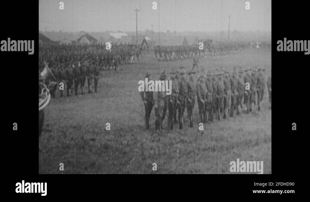 1920s: Army camp. Soldiers stand at attention. Teddy Roosevelt walks ...