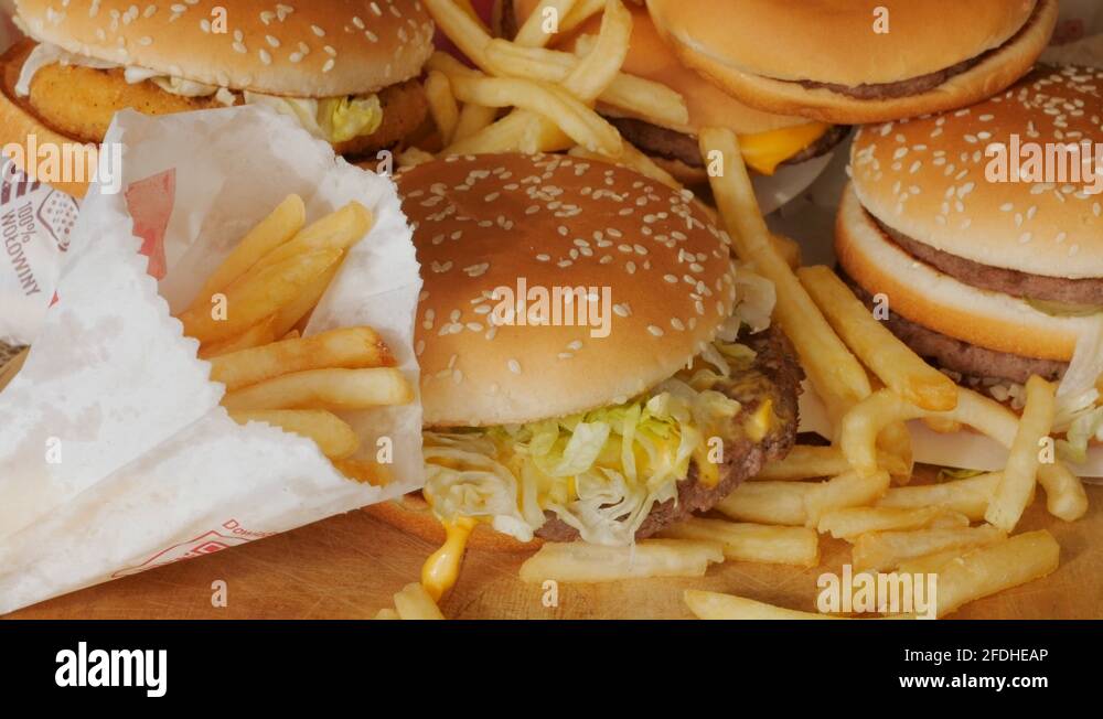portion of unhealthy food, fast food, stack of burgers, fries rotating ...