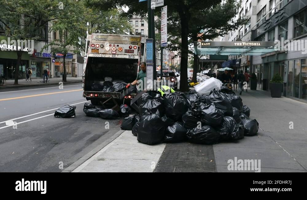 Garbage Truck in NYC and two DSNY workers Loading Black Garbage Trash ...