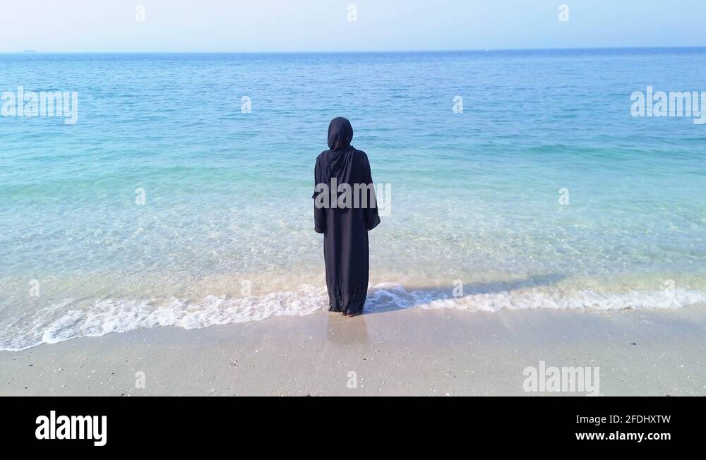 Muslim woman in the ocean with traditional clothing Stock Videos ...