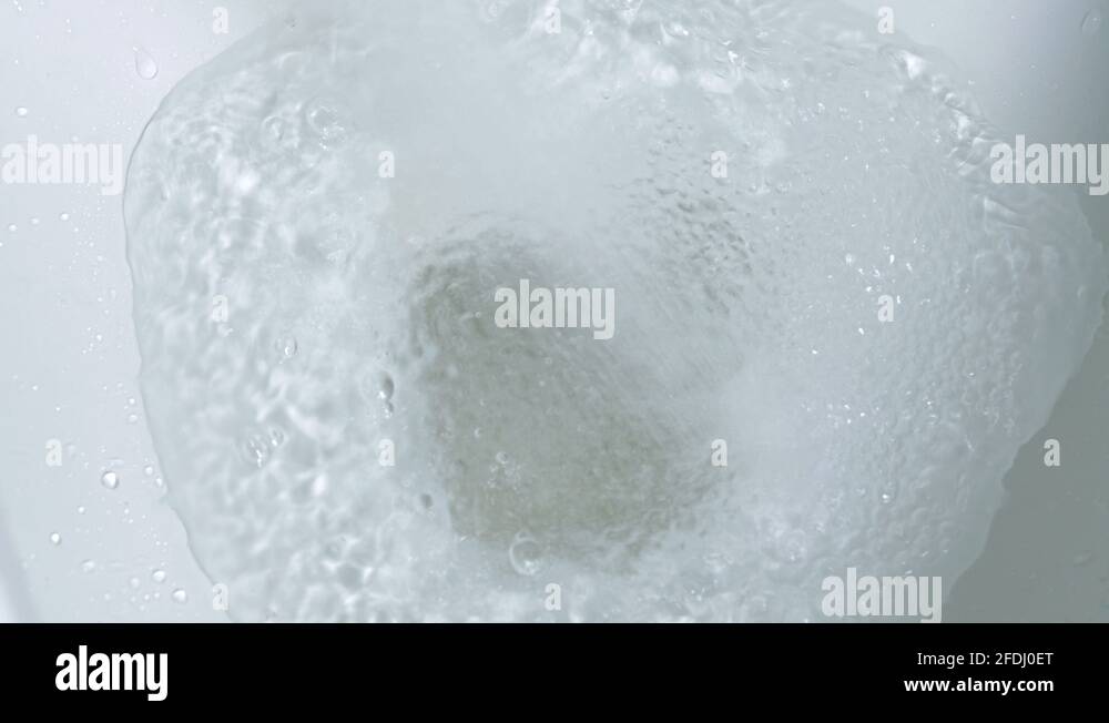 water is swirling in the toilet flush to clean and water being flushed ...