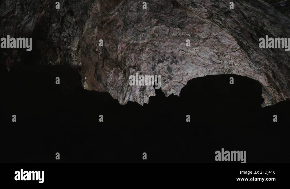 Cave explorer in a dark cave. Caver. Silhouette of a caver. Natural ...