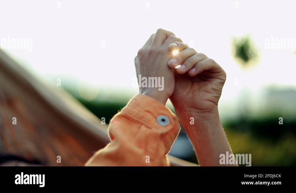 Lover hands caressing each other with sunlight lens-flare in background ...