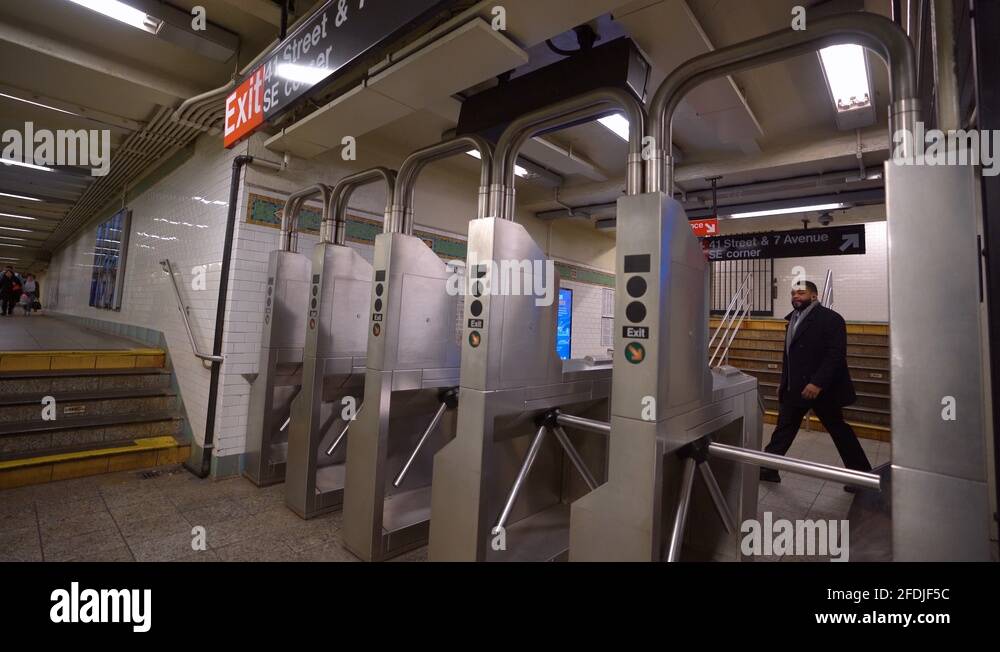 Lonely man walking through a gate inside a NYC Subway station, empty to ...