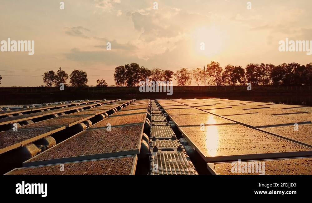 Floating solar farm project on Asian lake, sun reflecting at sunset ...
