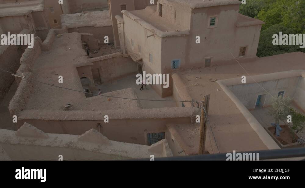 Arial observation-style view of sweeping in a Moroccan mud brick town ...