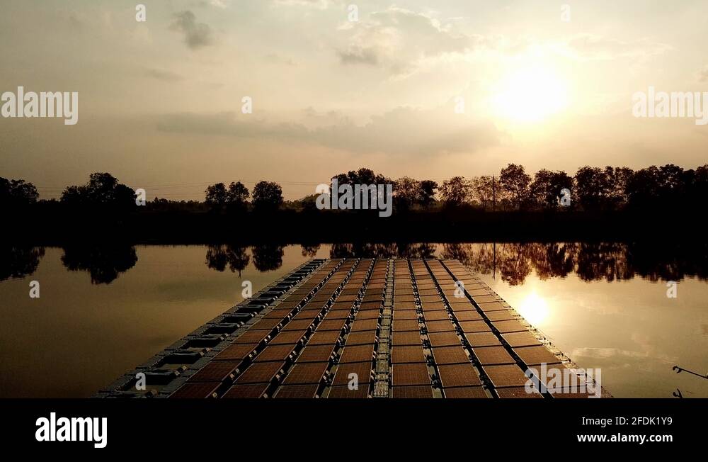 Floating solar farm installation project on lake in Asia at sunset ...