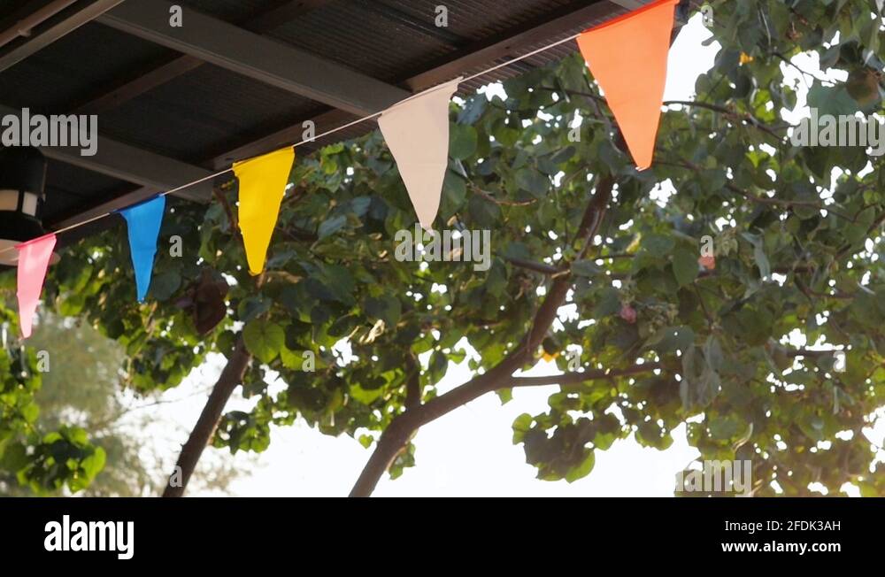 Colorful triangle flags blowing in the wind at a beach cafe. flags of ...