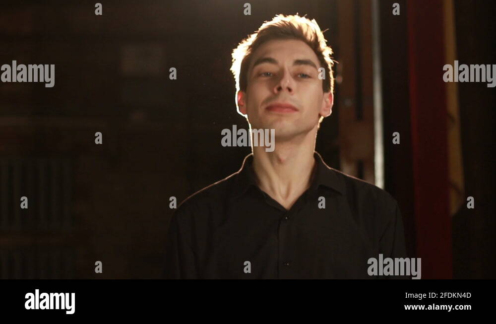 Handsome man says yes and nods his head against backlight background ...