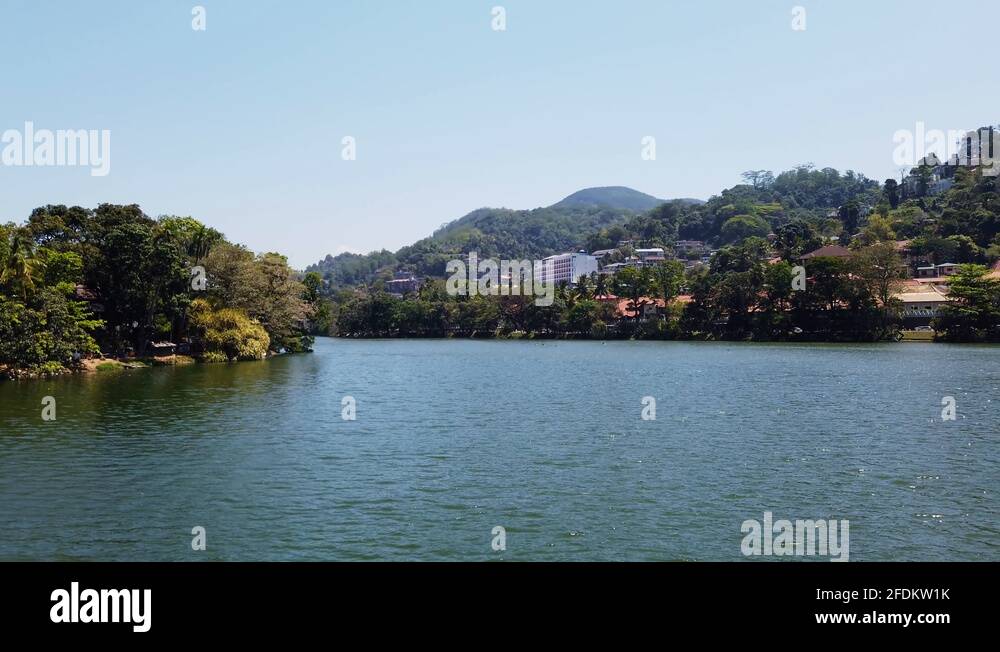 The stunning scenery of Kandy Lake in Sri Lanka with trees and houses ...