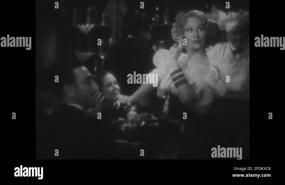 1940s: Woman speaks and sits tray on bar in crowded tavern. Woman sings ...