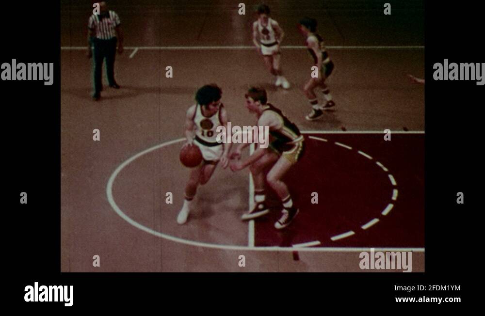 1970s: Man dribbles ball and charges player in slow motion. Man ...