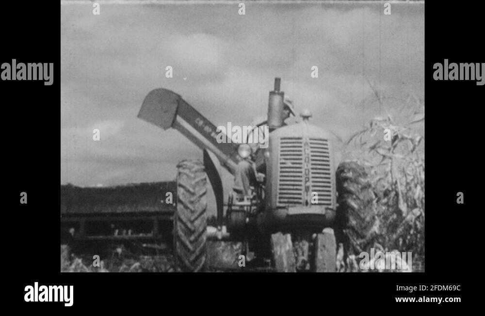 1960s: UNITED STATES: tractor on farm. Farm Machinery sign and display ...