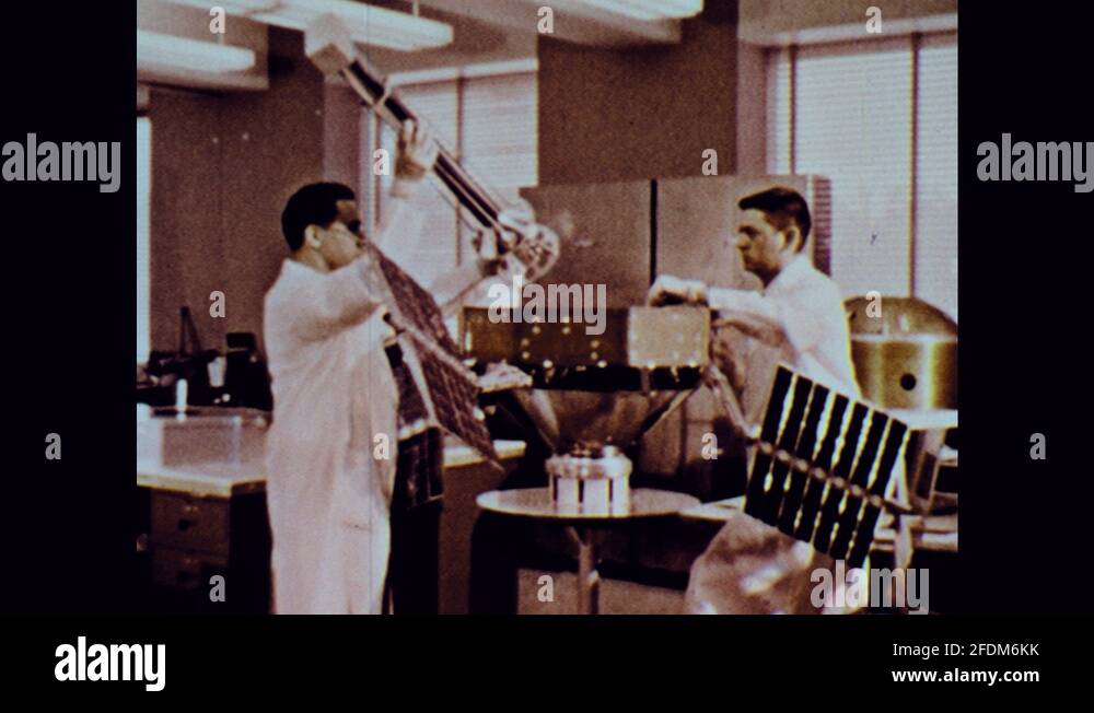 1990s: Two men in laboratory build pieces of spacecraft. Men in lab ...