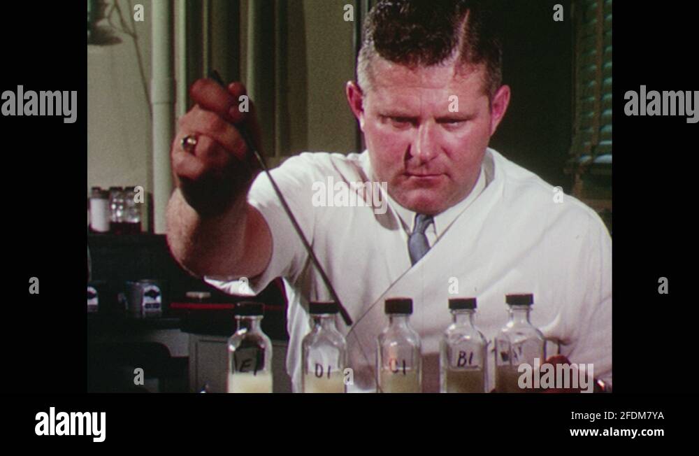 1960s: Scientist dips a pipette into various solutions in a laboratory ...