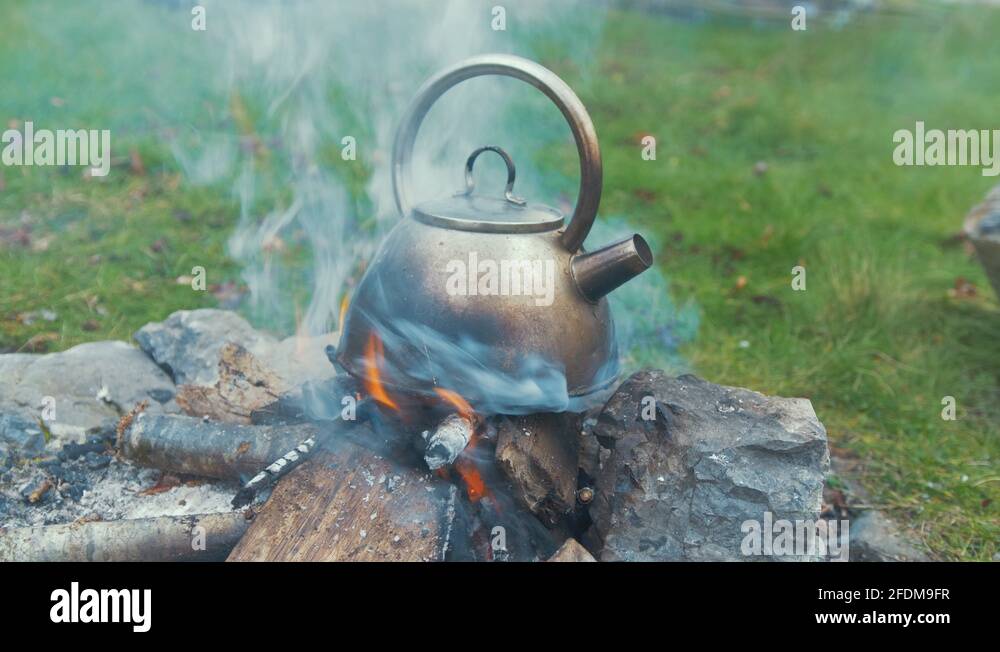 Stainless steel kettle boiling water over camp fire 4K Stock Video ...