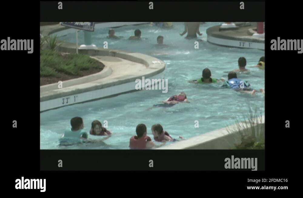 1990s: People float down lazy river. People slide down water slide. Boy ...