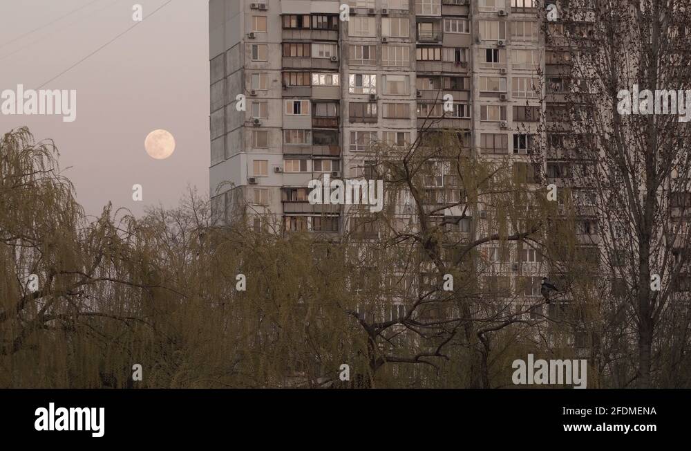 Full moon is rising by old high rise in spring. Kyiv, Ukraine. 4K UHD ...