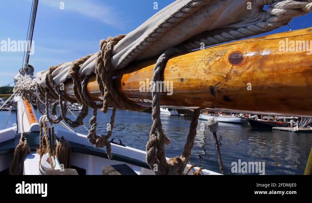 The front sail of an old wooden ship pulled down and lashed down with ...