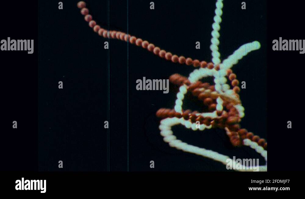 1960s: Two different colored strings of beads move around in tank of ...