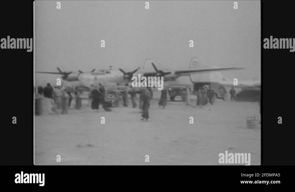 1940s: Soldiers around planes on airfield. Soldiers unload barrel from ...