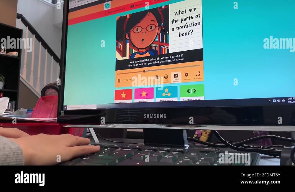 Child using a personal computer to do a reading assignment assigned by ...