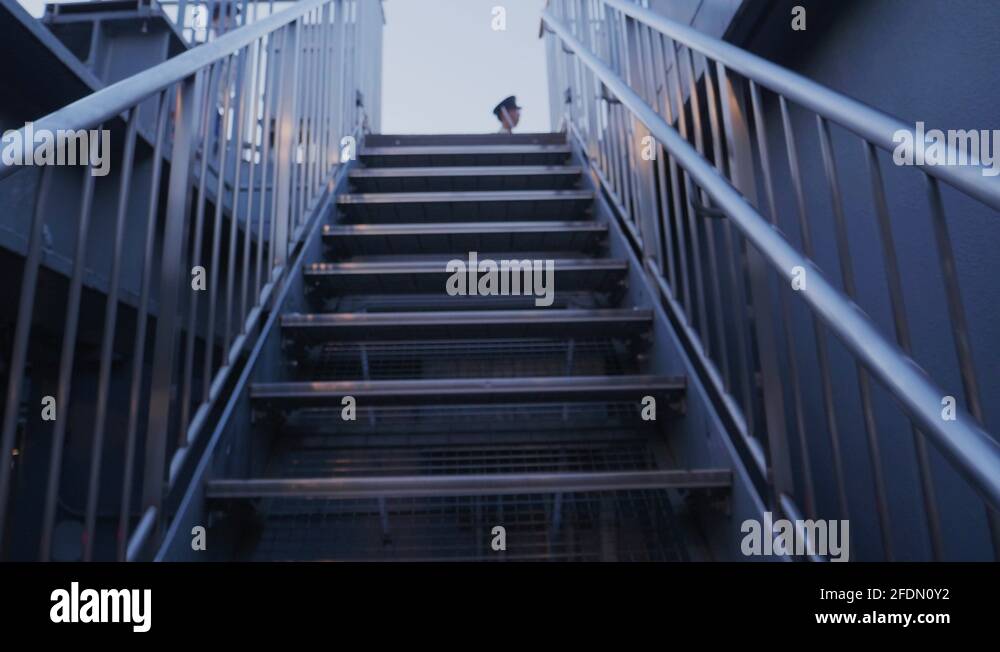 Camera walking up metal stairs on to a helicopter landing pad in Tokyo ...
