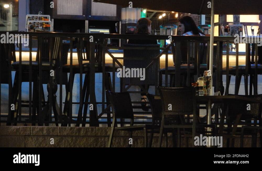 Two Women Talking To Each Other At Night At Outdoor Poolside Bar Resort ...
