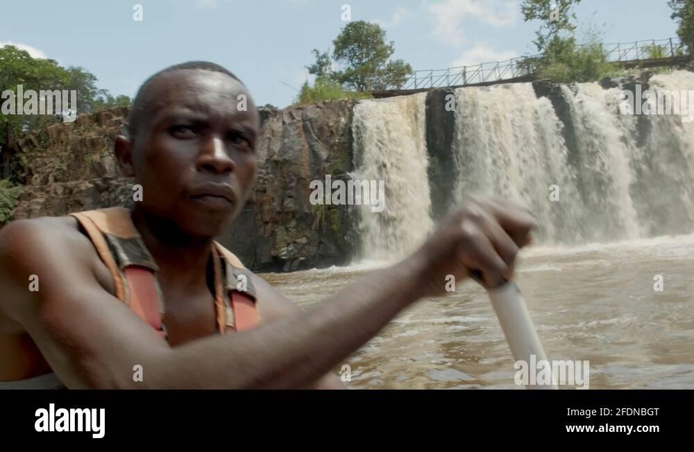 African man paddles raft on river with waterfalls Stock Video Footage ...