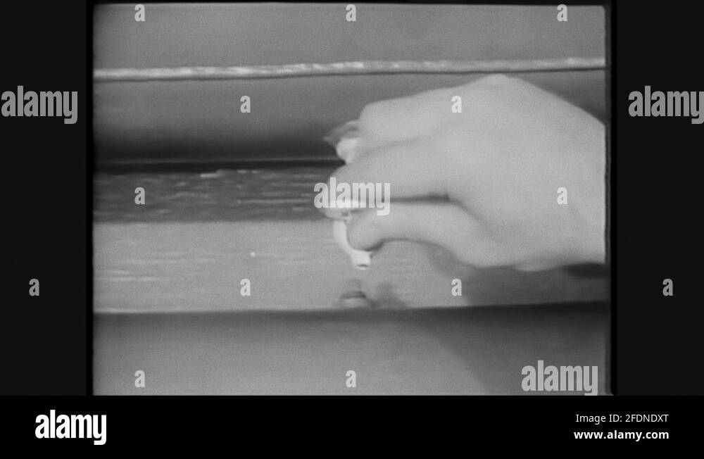 1960s: Man opens valve on tank, empties water from tank. Man turns ...