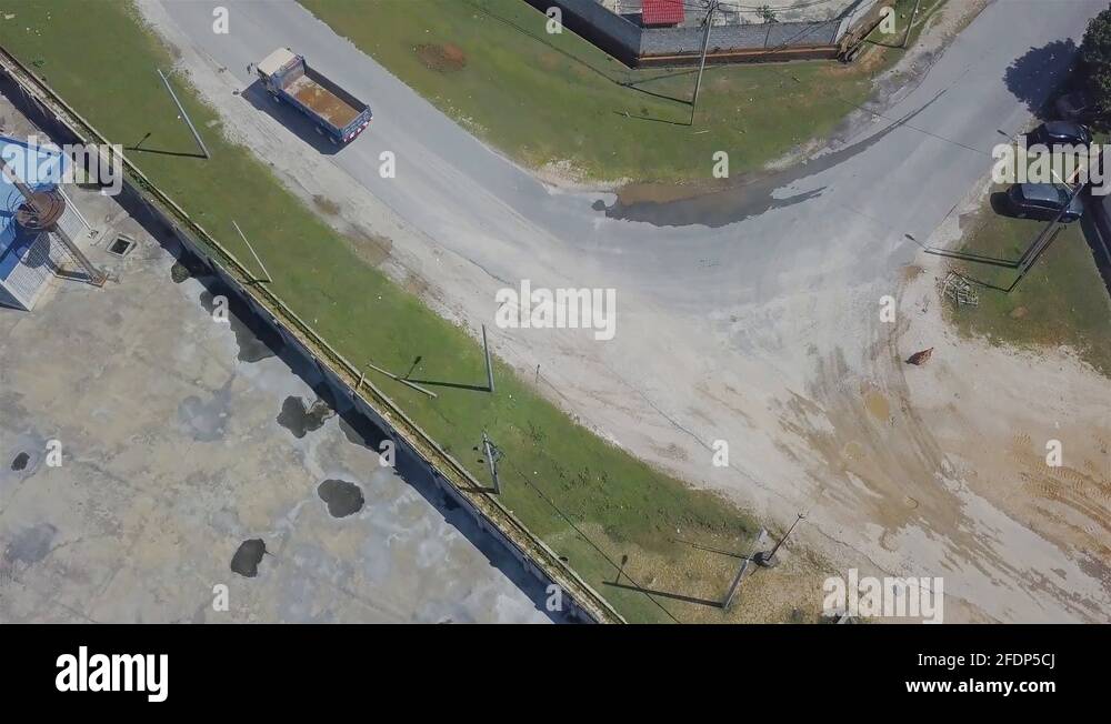 Empty lorry driving away on the road surrounded with paths - Tilt up ...