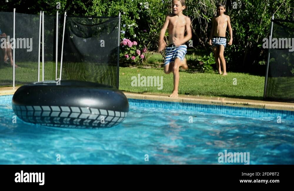 Children having fun at the pool. Kids running and jumping into water ...