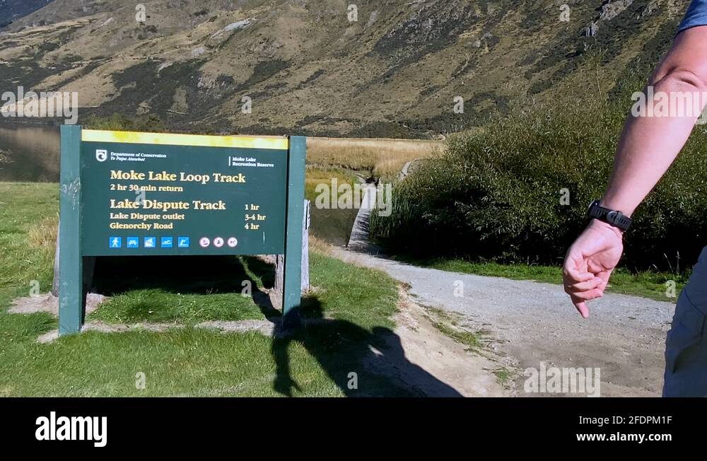 Man and Woman at start point sign for Moke Lake Loop Track, New Zealand ...