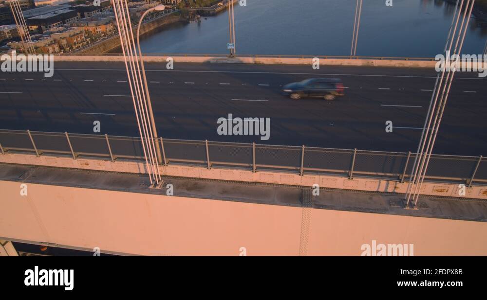 Floating beside a freeway bridge watching the cars pass at sunrise when ...