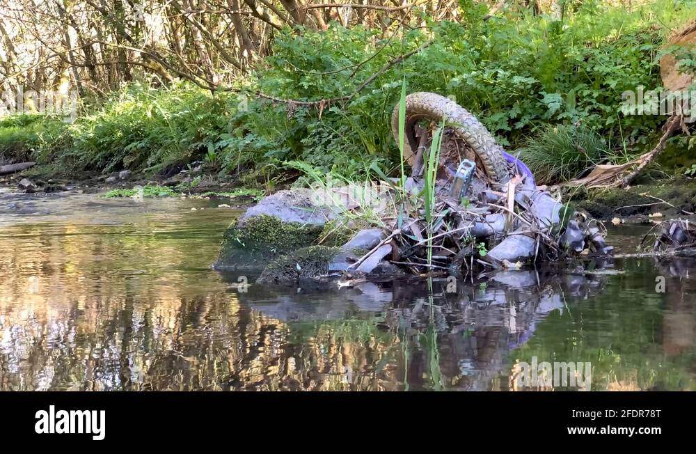 Bicycle dumped in river. Water pollution Stock Video Footage - Alamy