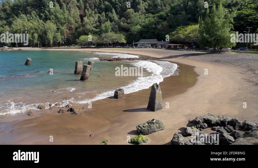 Hana Bay on Maui with lava sand and pilings from on old sugar pier ...
