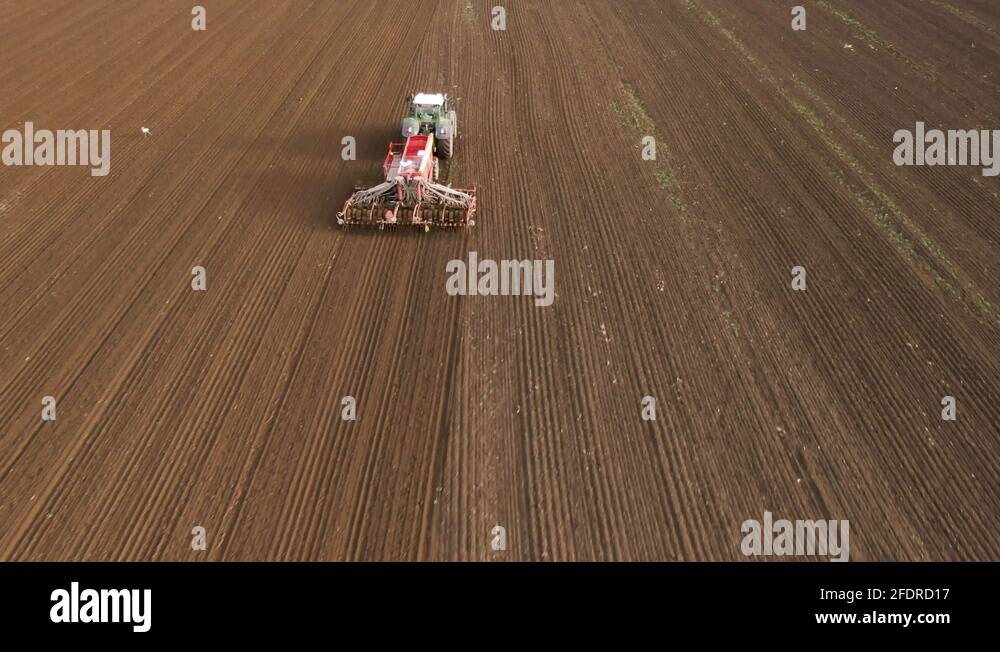 Tractor in working in the field. Tractor with a modern sowing seeds ...