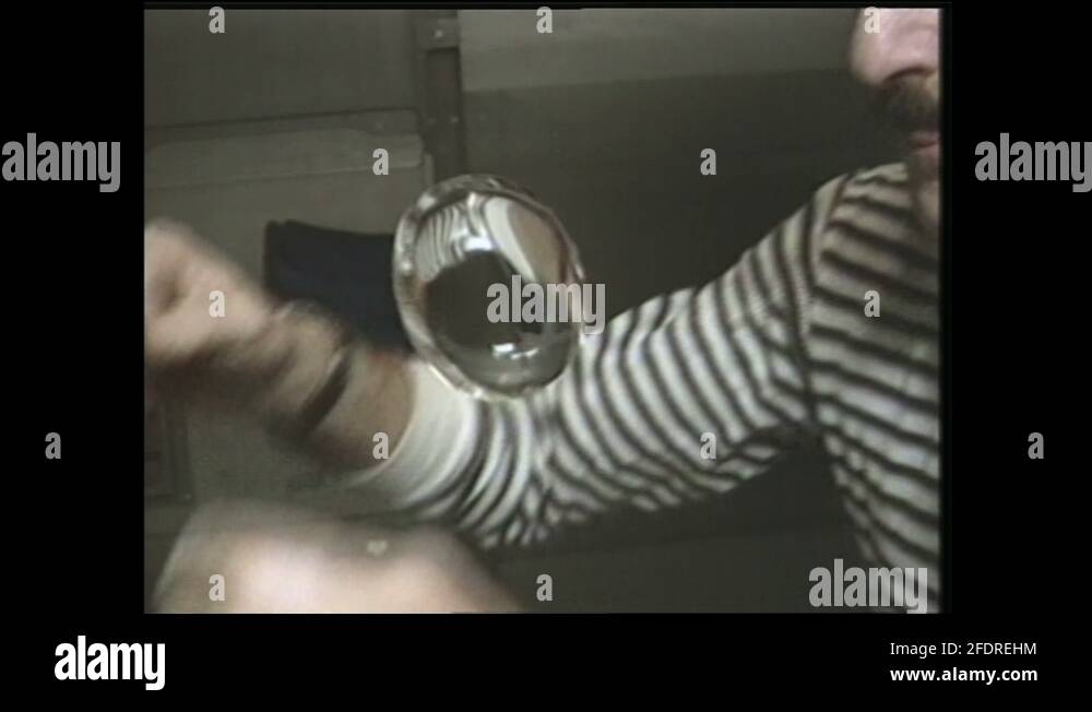 1990s: Space shuttle, man floats, moves hands around bubble of water ...