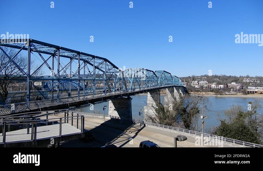 Pedestrians Crossing Blue Bridge With Tresses And Scenic Waterfront ...