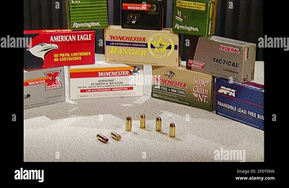 1990s: Bullets are lined up in front of display of ammunition boxes. A ...
